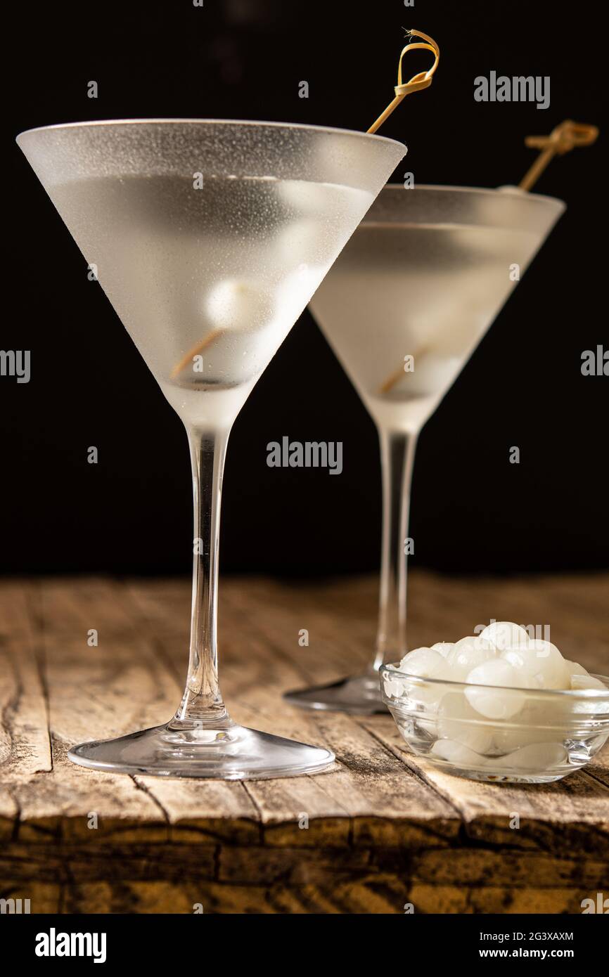 Gibson martini cocktail with onions on wooden table and black ...