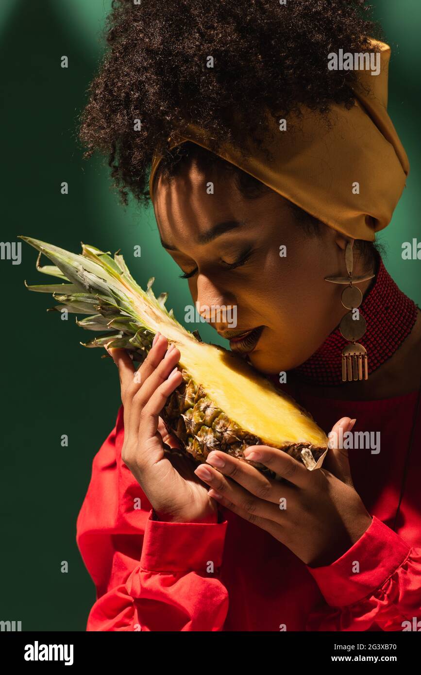 young african american woman with closed eyes holding half cut of ...