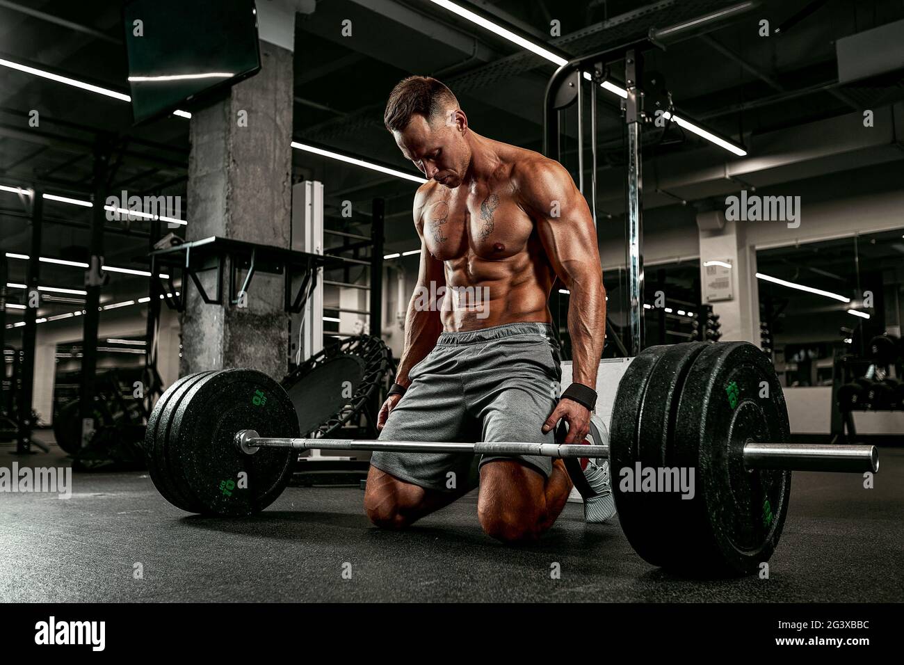 Injury athlete with a barbell preparing for a workout in the gym for ...