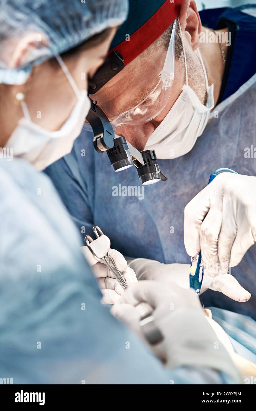 Surgeons men and women in one team during an operation over the ...