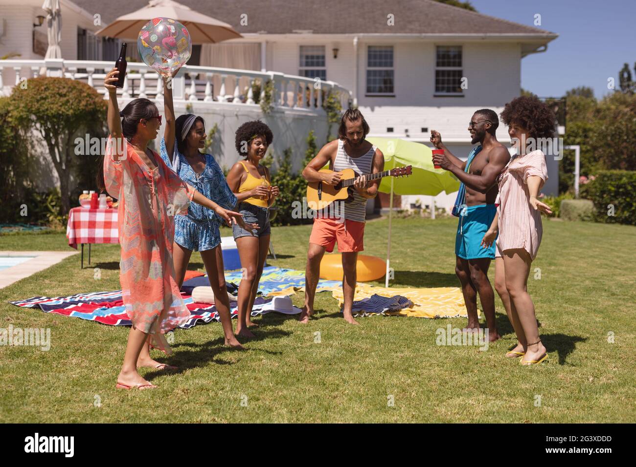 Diverse group of friends dancing and smiling at a pool party Stock ...
