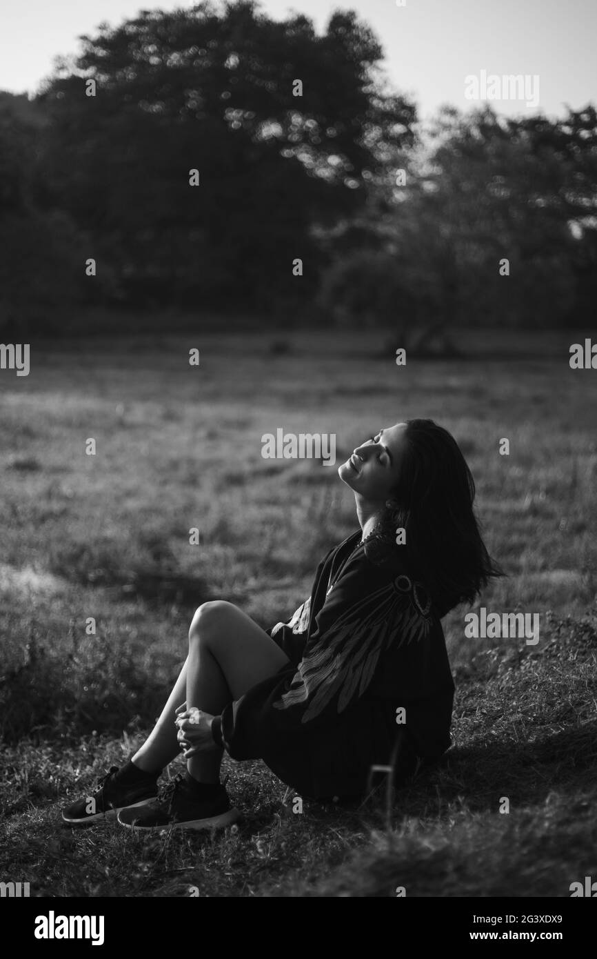woman sitting alone in a park during sunrise Stock Photo - Alamy