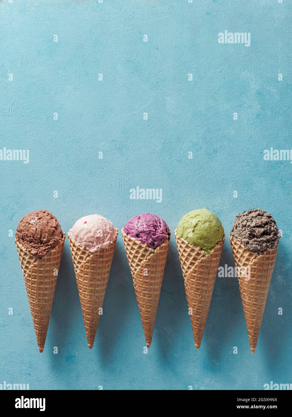 Ice cream scoops in cones with copy space on blue Stock Photo - Alamy