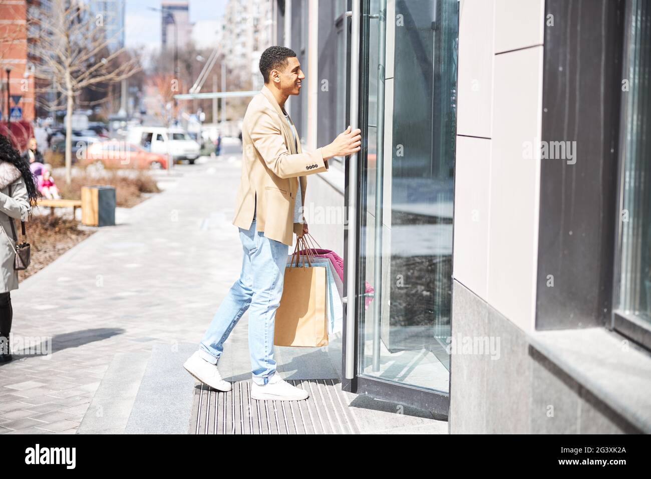 Young handsome man entering building for shopping Stock Photo - Alamy