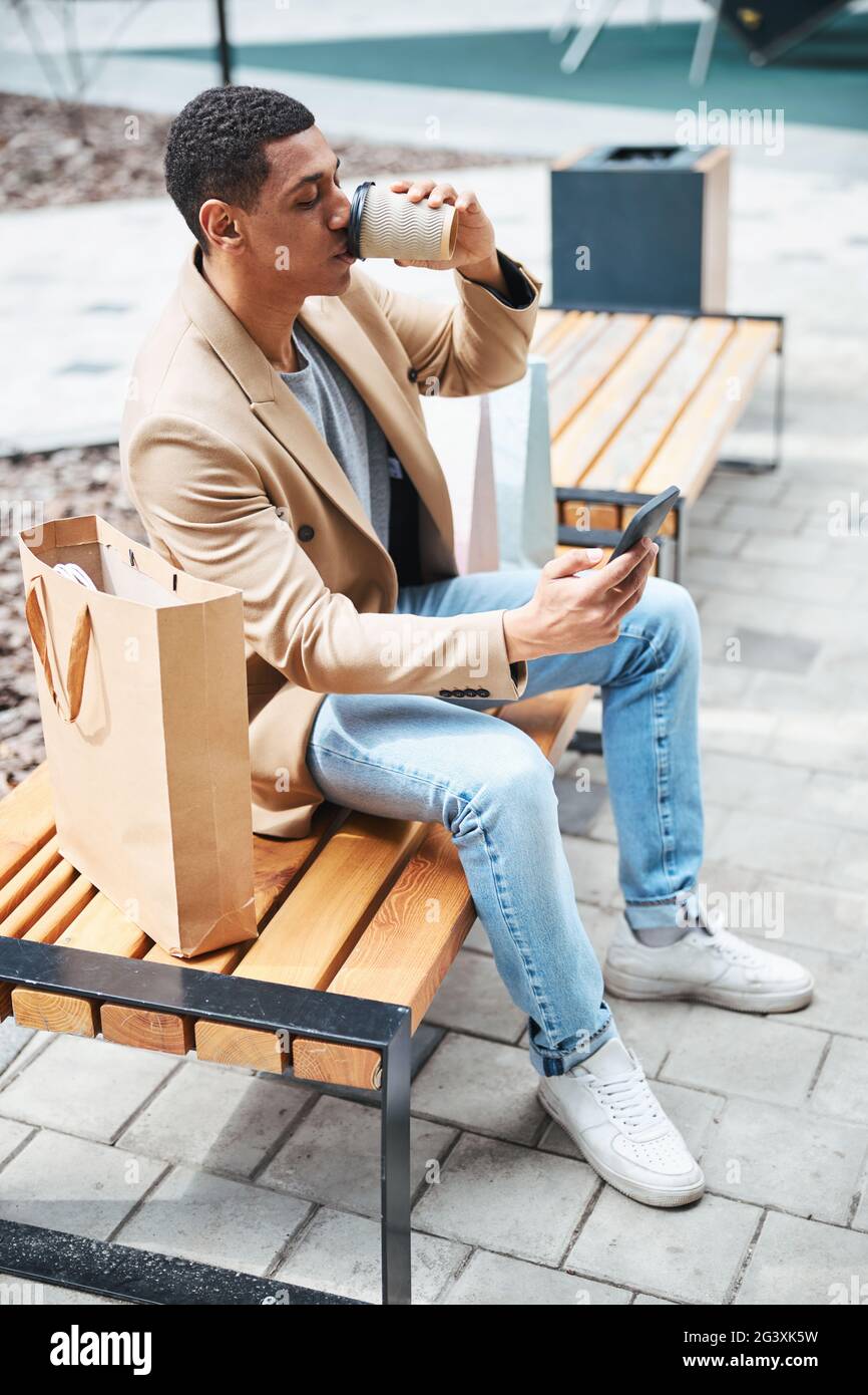 Relaxed male person staring at screen of telephone Stock Photo - Alamy