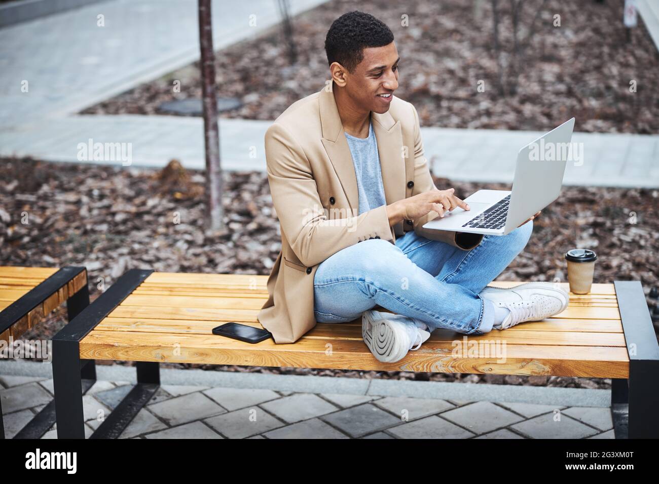 Positive delighted male person using his laptop Stock Photo - Alamy
