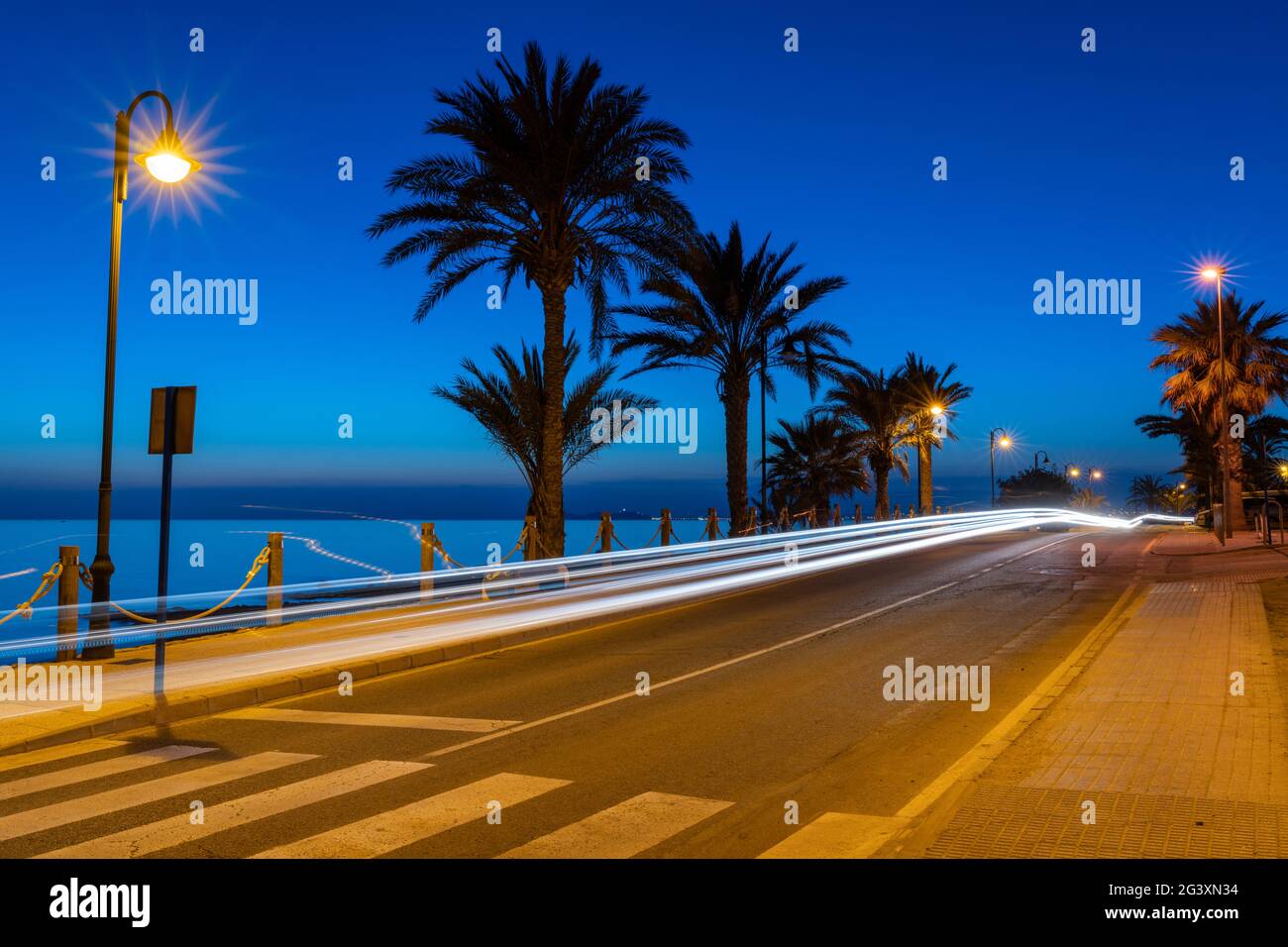 A long exposure night view of ocean front street with light lines from ...