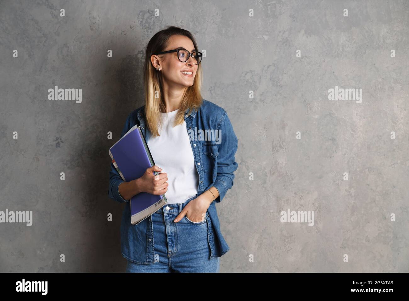 Happy attractive young casual woman student holding notebooks while ...