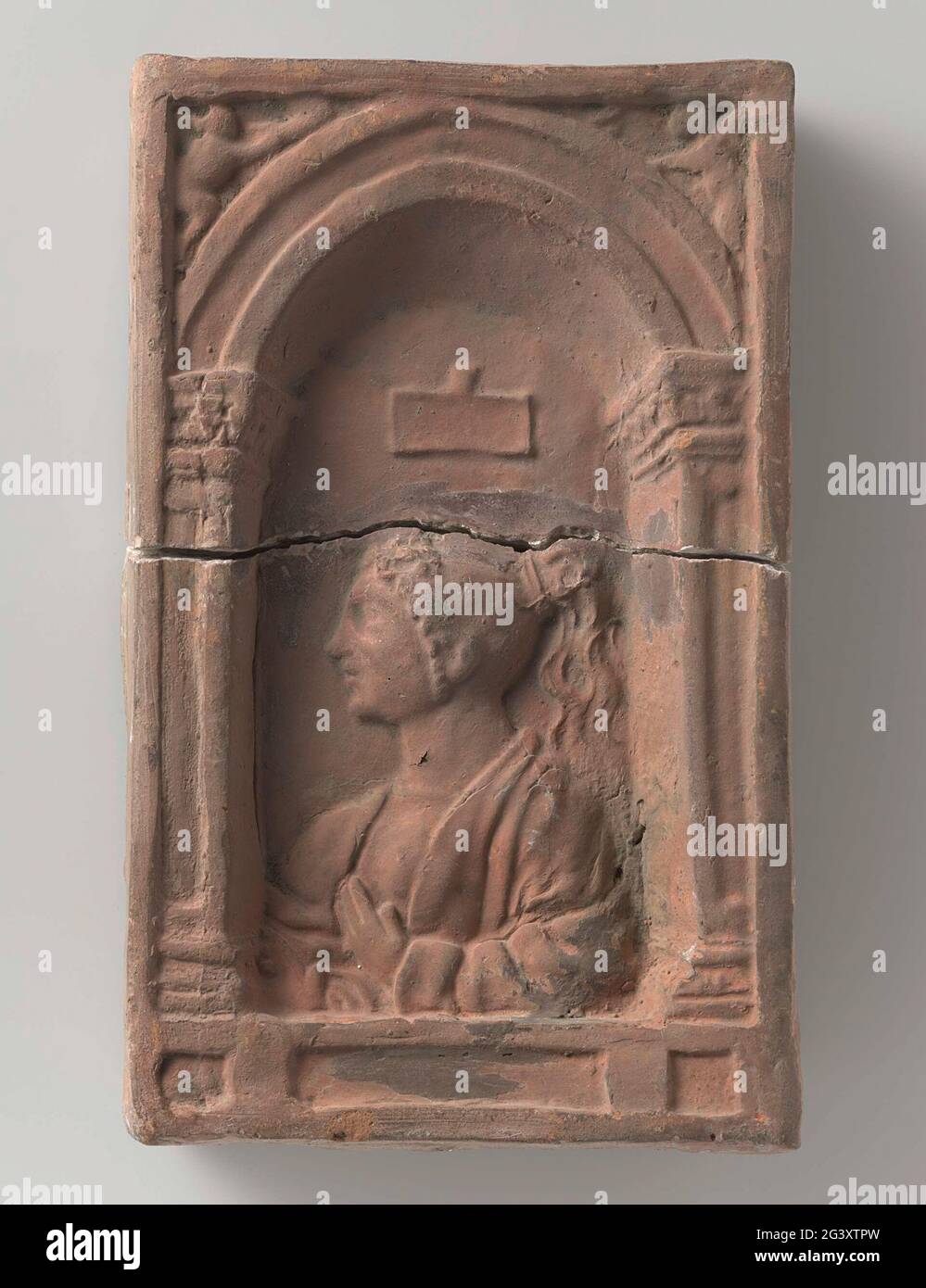 Brick on which a woman's bust is in a window in relief. A brick on ...