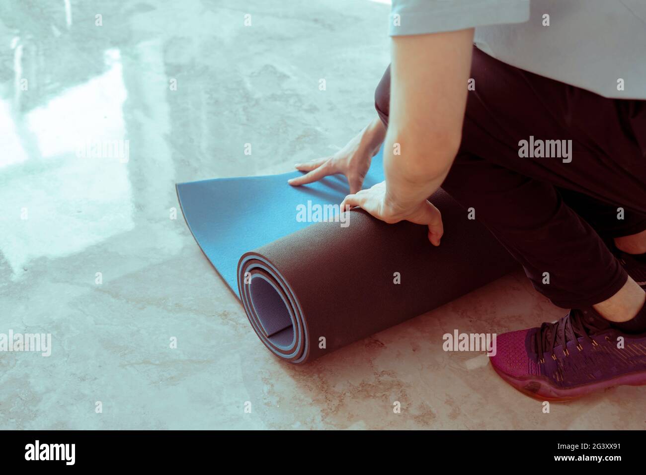 man rolling the yoga mat on the floor in yoga class workout Stock Photo ...