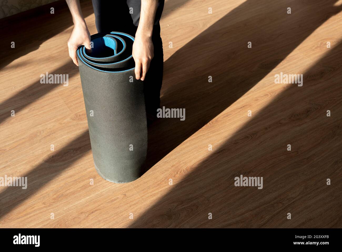 man rolling the yoga mat on the floor in yoga class workout Stock Photo ...