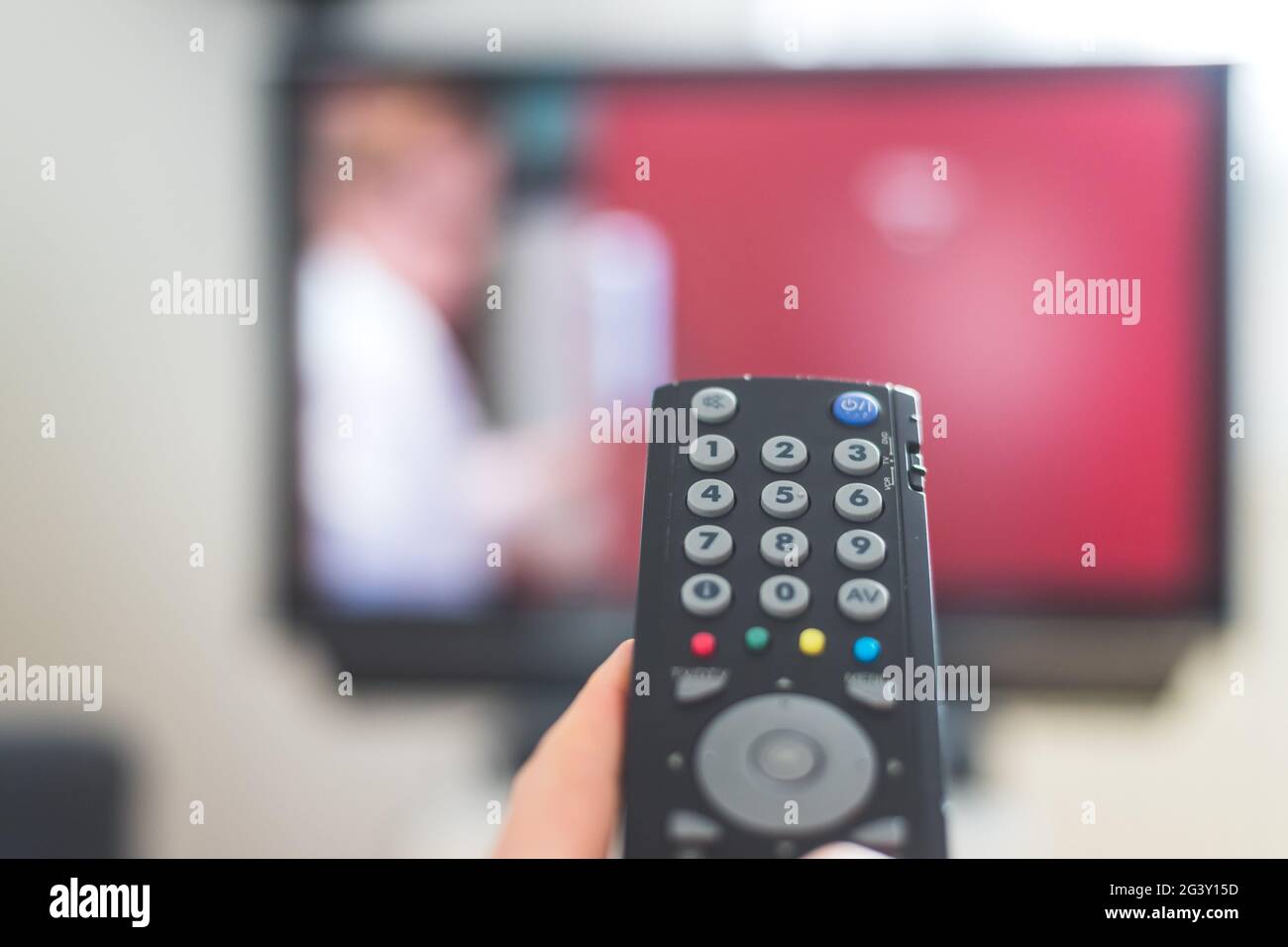 Male hand is holding TV remote control, streaming on a smart TV Stock ...