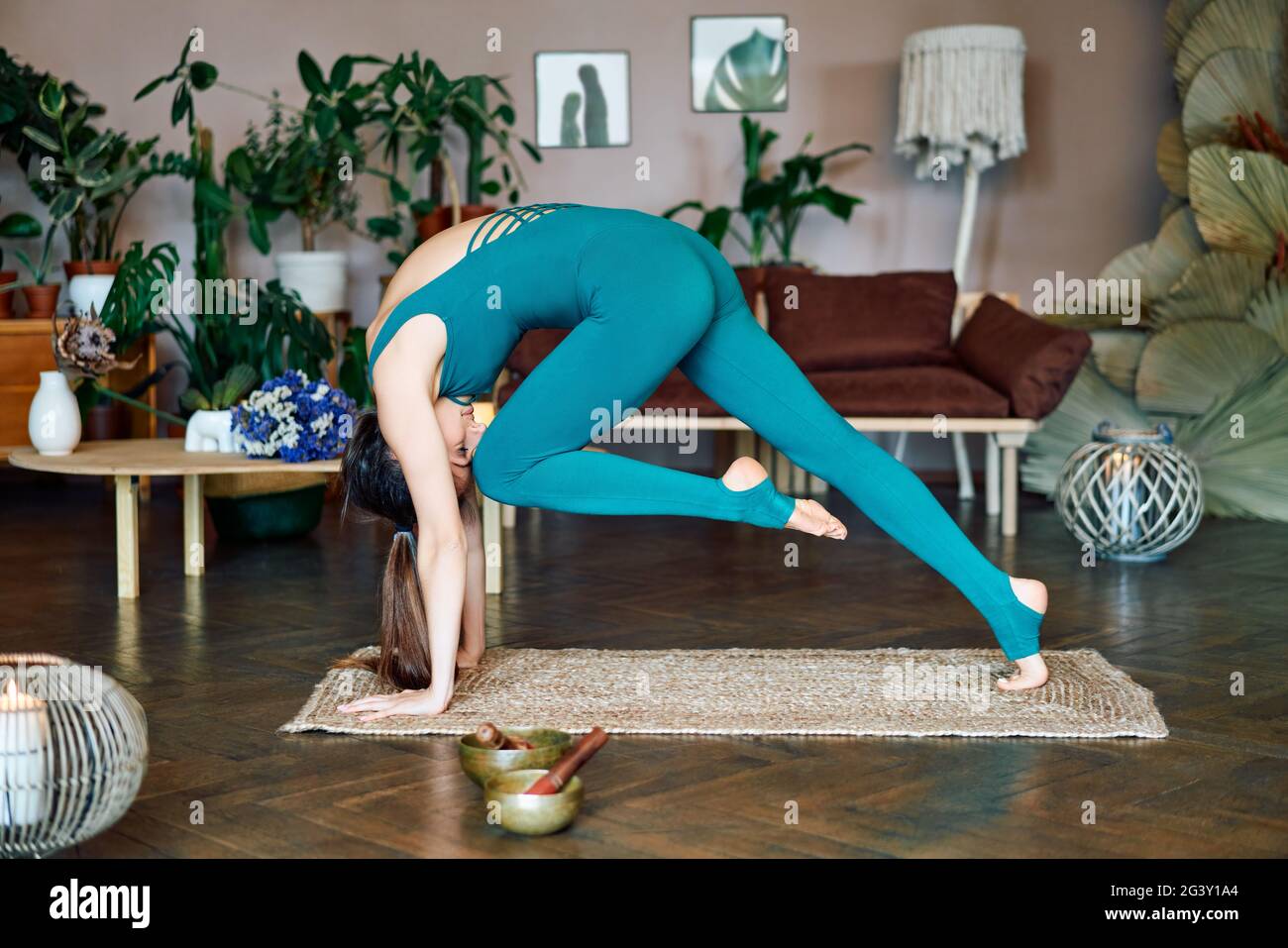 Woman practicing yoga doing knee to forehead exercise, plank pose at ...