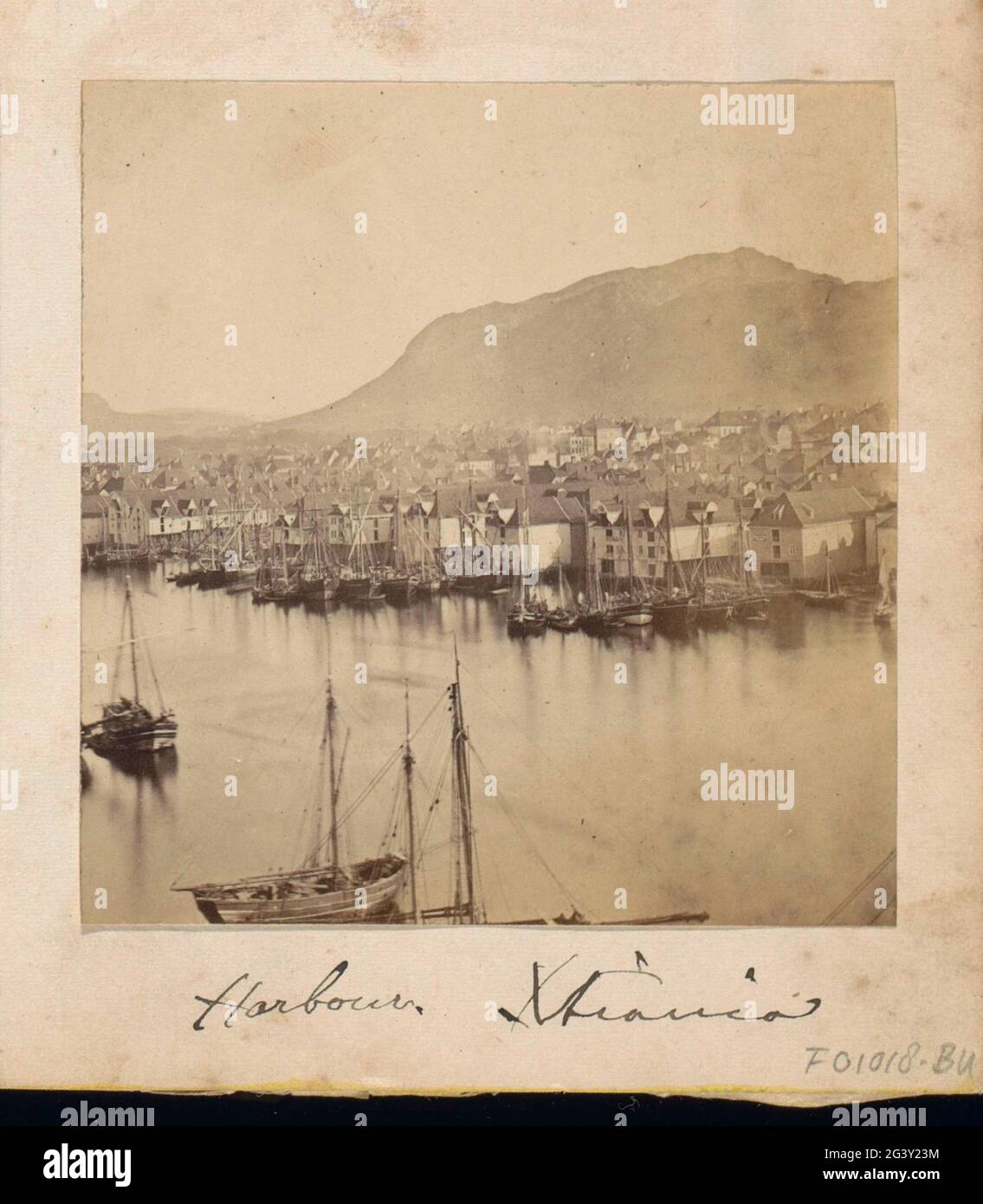 View of ships and warehouses in the port of Christiania with mountains ...