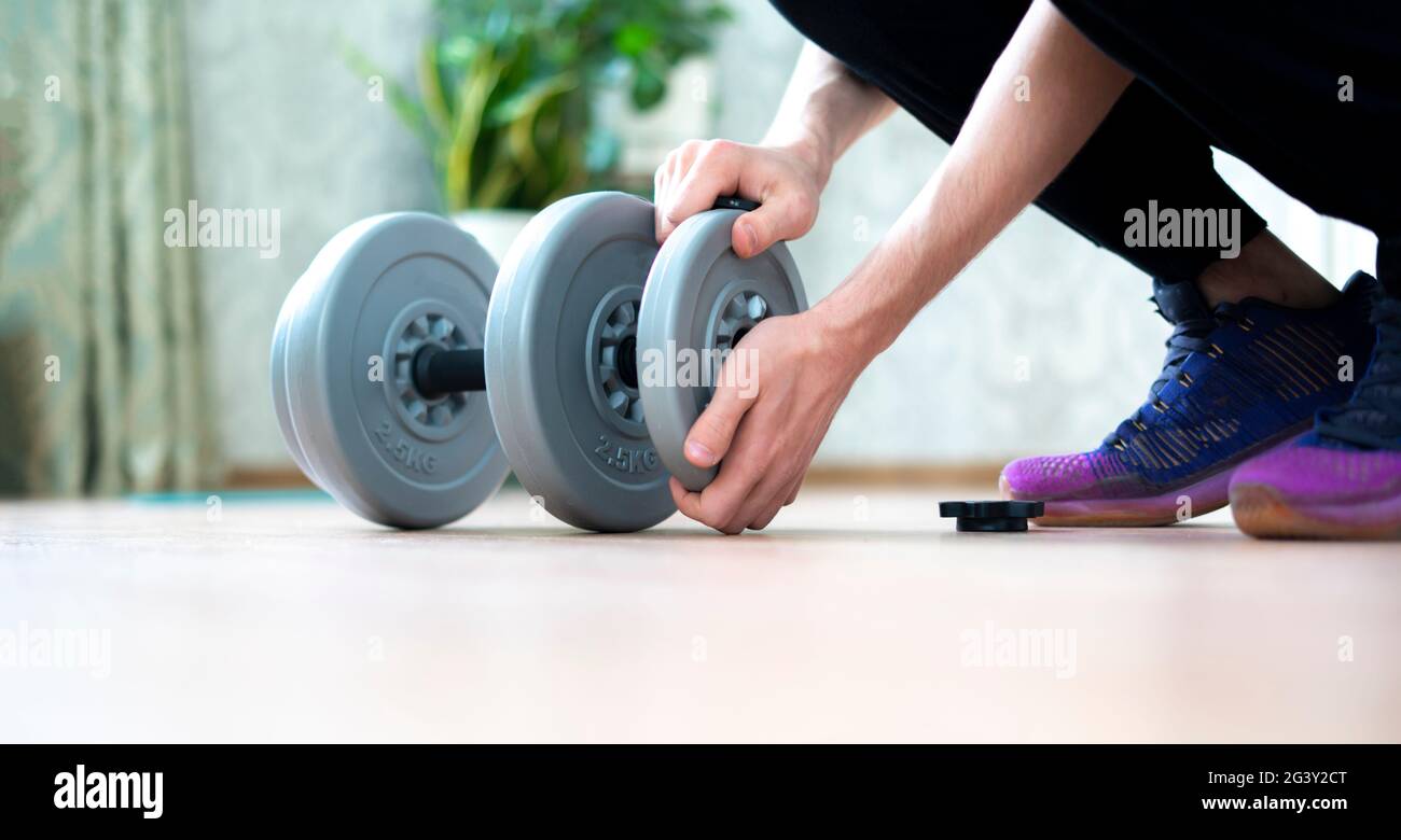 person doing workout and put on a weght disc on a barbell dumbbell ...