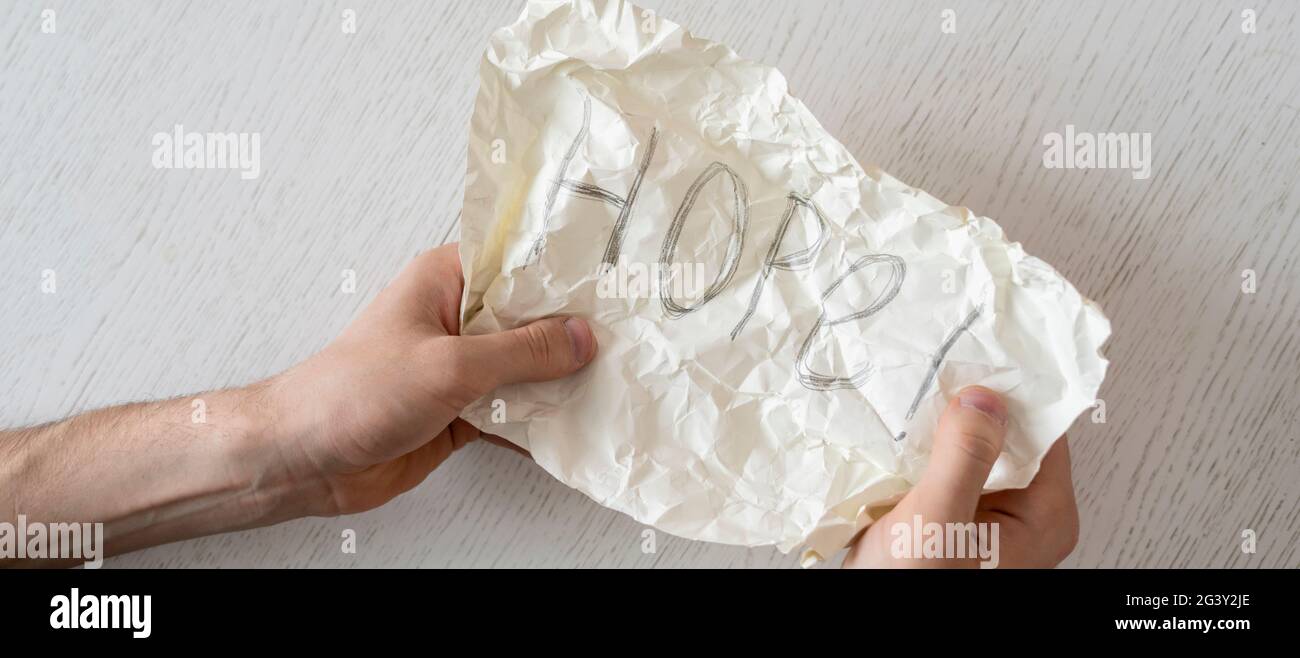a person hands holding a paper sheet with the hope word Stock Photo - Alamy