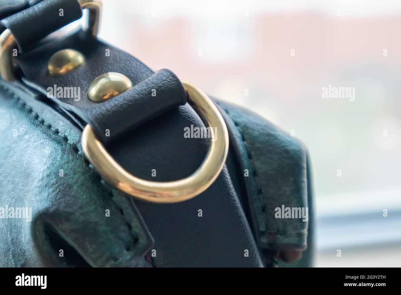 Metal gold loop oval ring attached to a leather bag. Selective focus ...