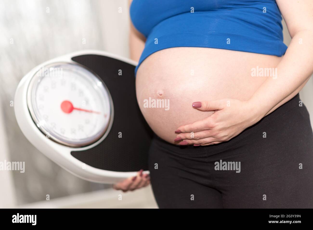 Pregnant woman holding a scale Stock Photo - Alamy