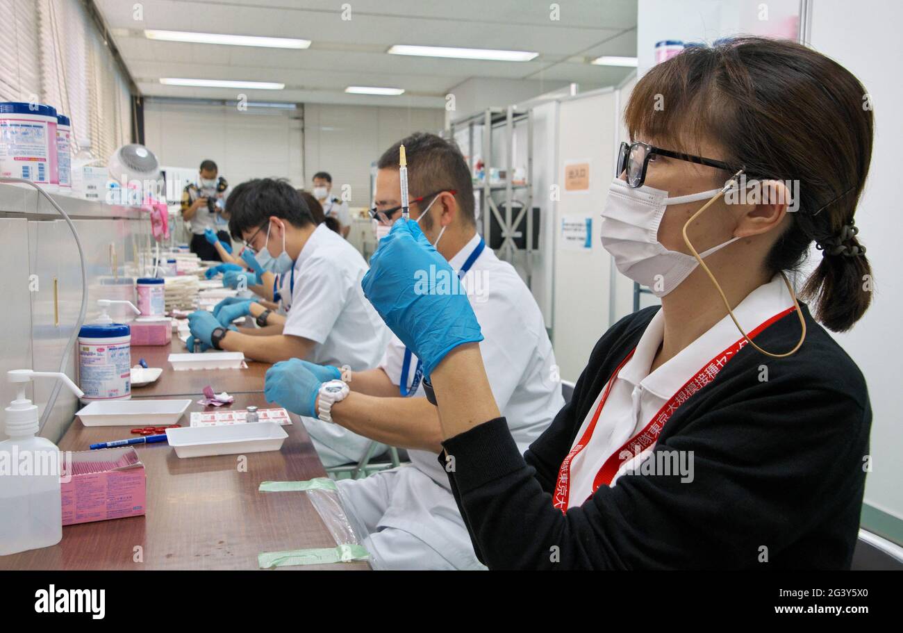 Tokyo, Japan. 18th June, 2021. A medical worker fills a syringe with a ...