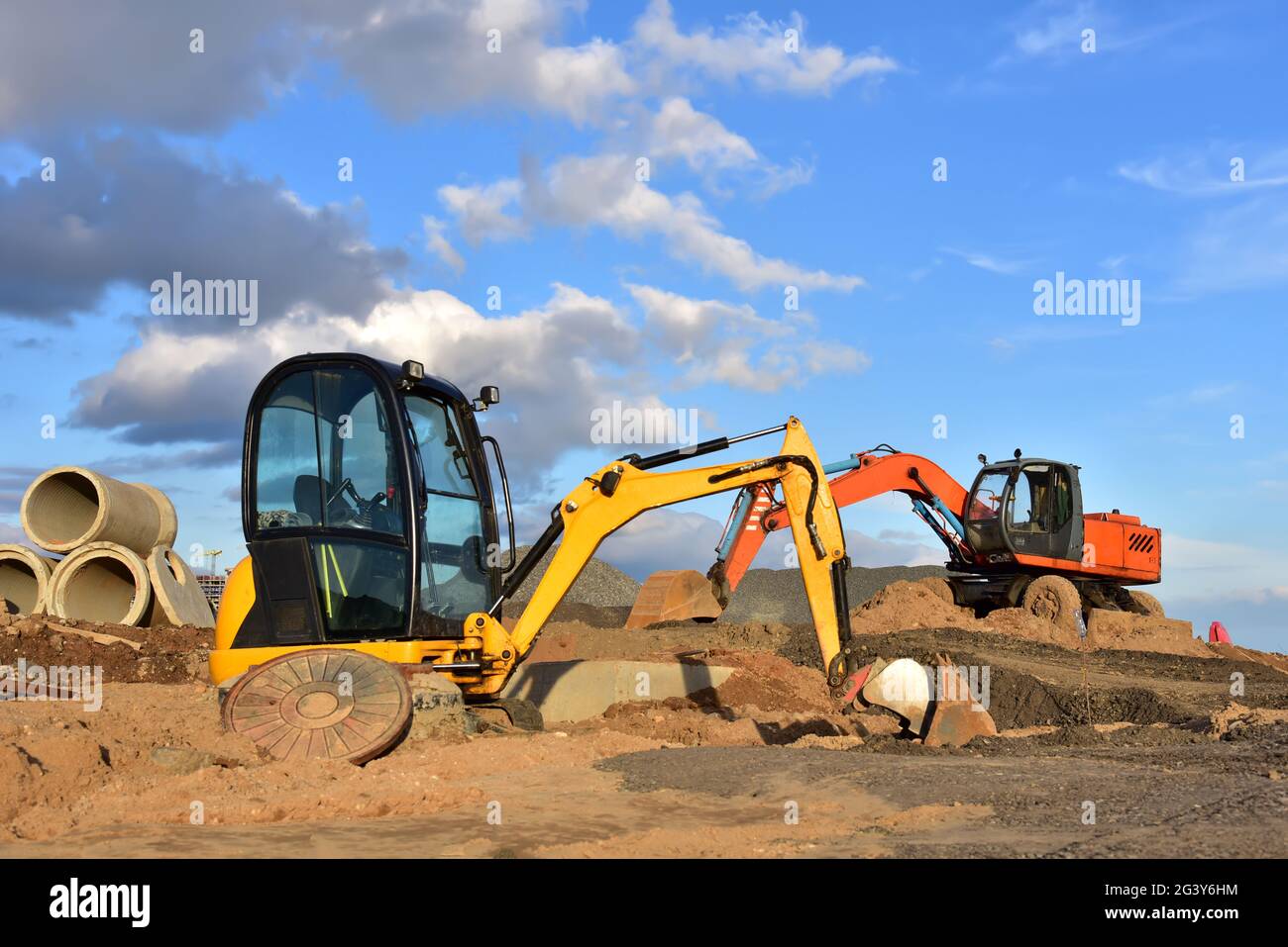 Mini excavator during earthmoving at construction site. Backhoe dig ...