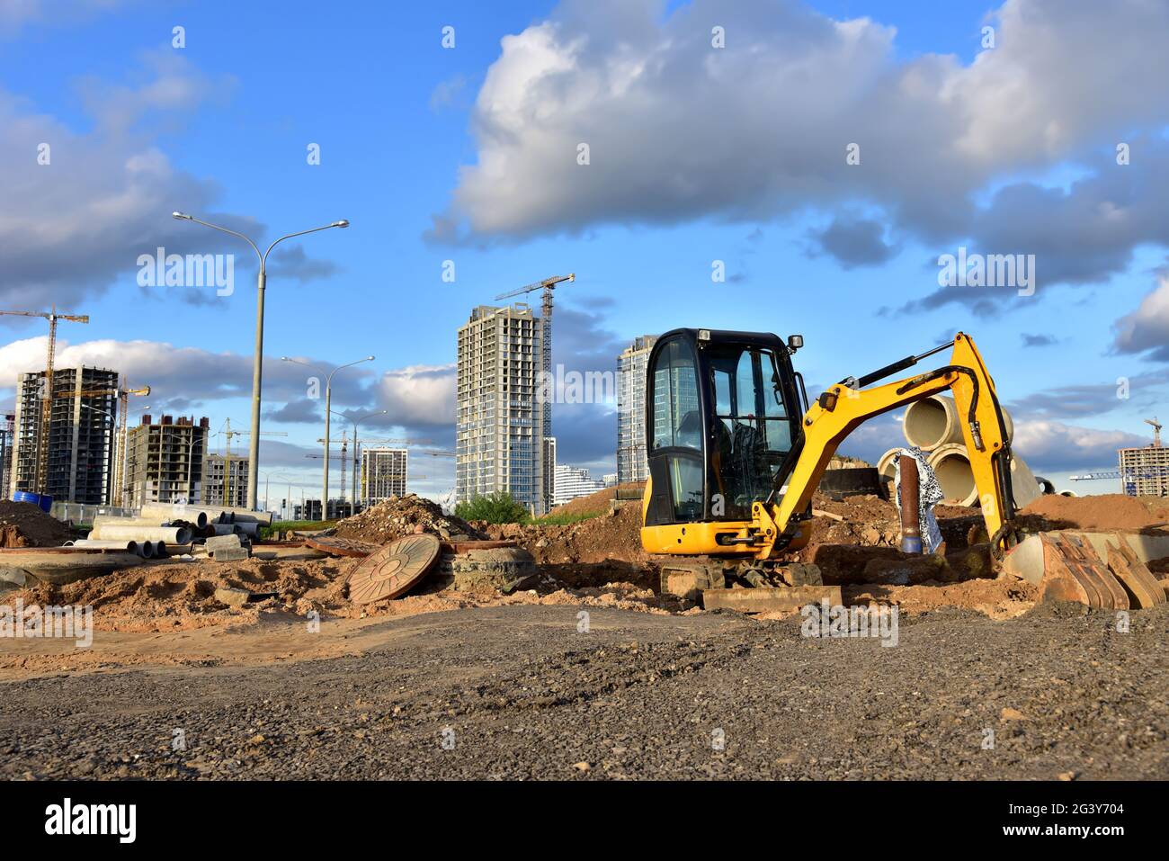 Mini excavator during earthmoving at construction site. Backhoe dig ...