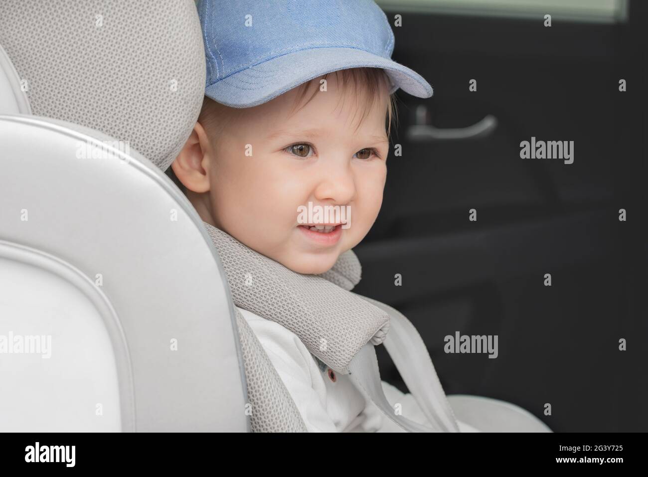 Boy sitting in a car in safety chair. Portrait of cute boy sitting in ...