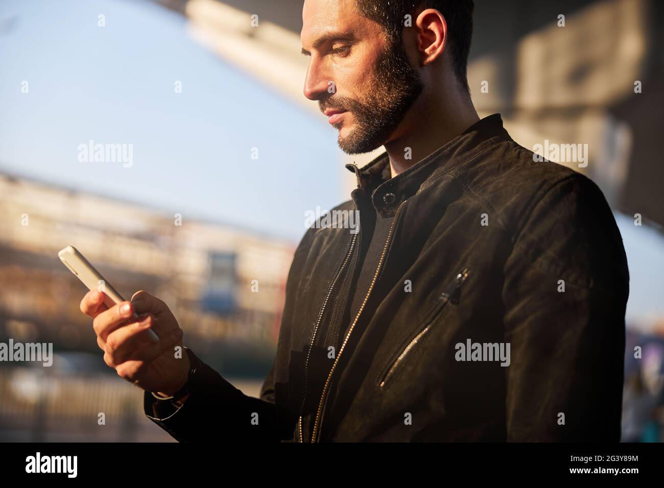 Portrait of handsome man using modern gadget in the street Stock Photo ...