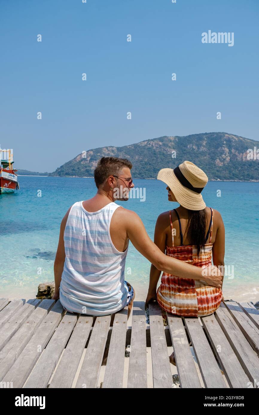 Couple from behind on the backside looking out over ocean of tropical ...