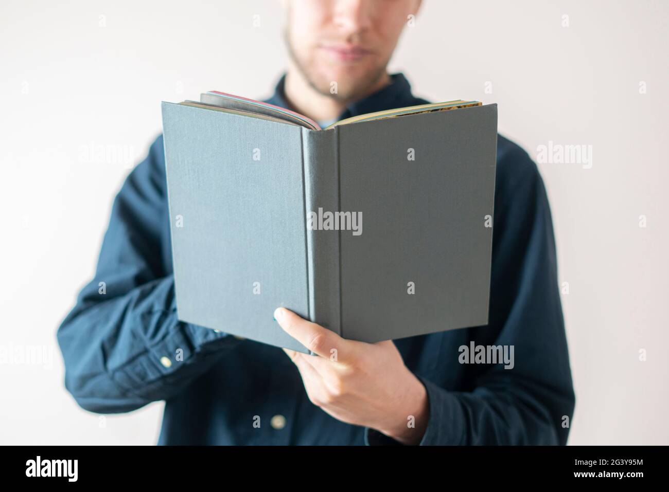 young man holding a book, reading and get knowledge standing near the ...