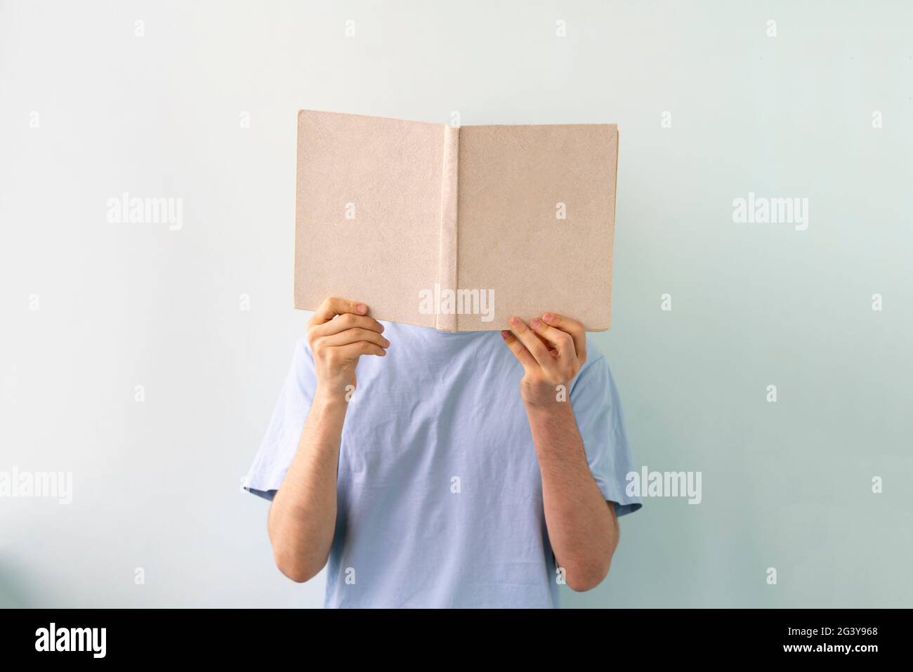 young man holding a book, reading and get knowledge standing near the ...