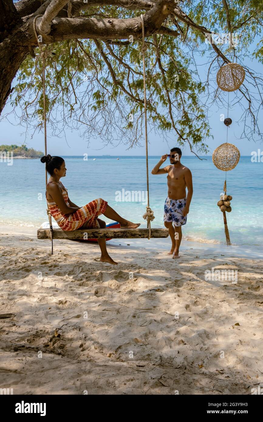 Couple from behind on the backside looking out over ocean of tropical ...