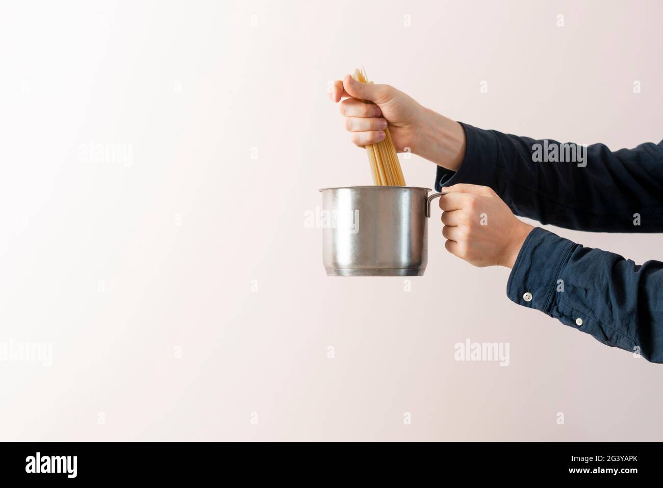 hands holding a bunch of raw spaghetti and cook it. italian noodle ...