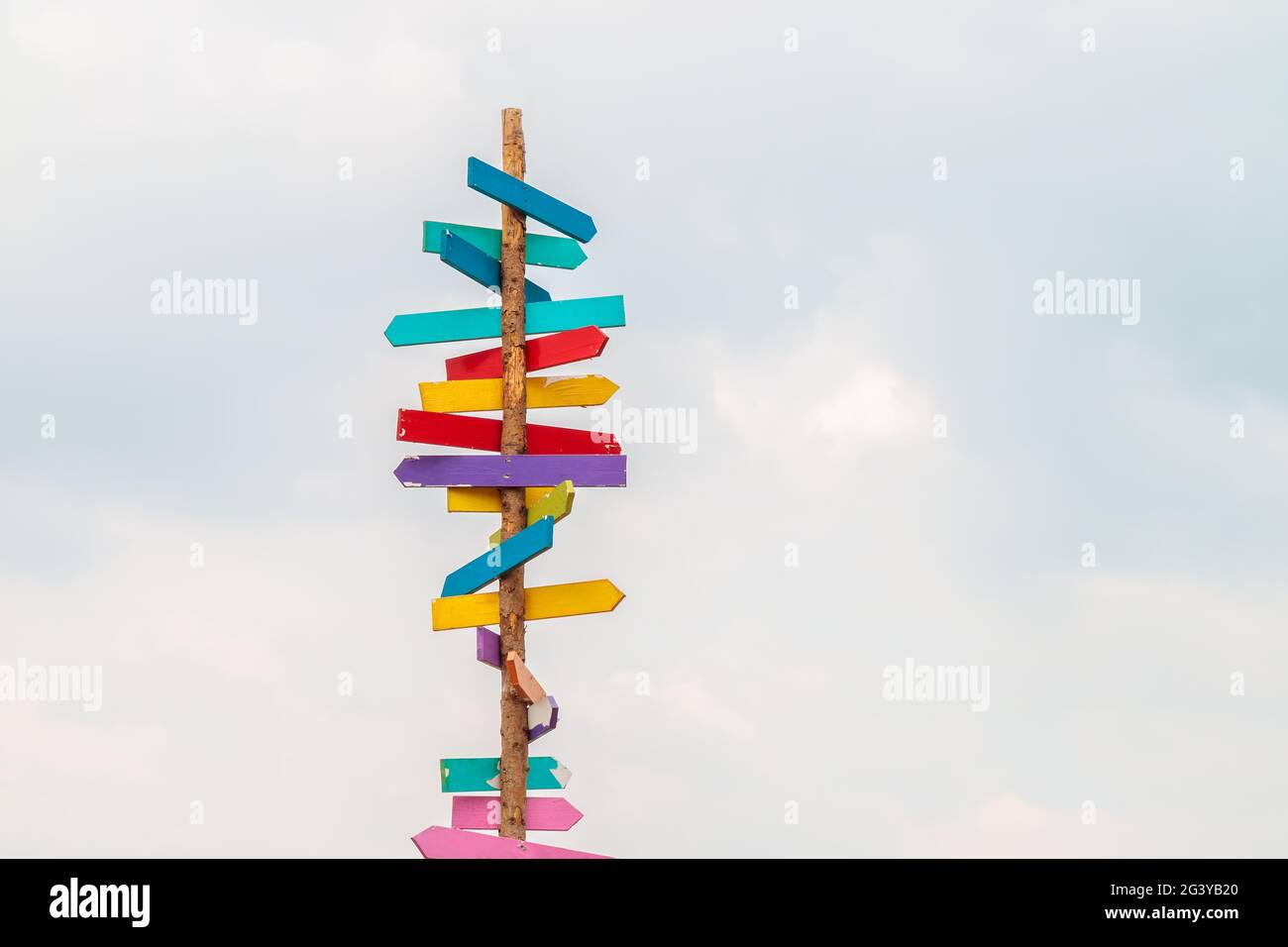 Colorful wooden direction arrow signs on a wooden pole Stock Photo - Alamy