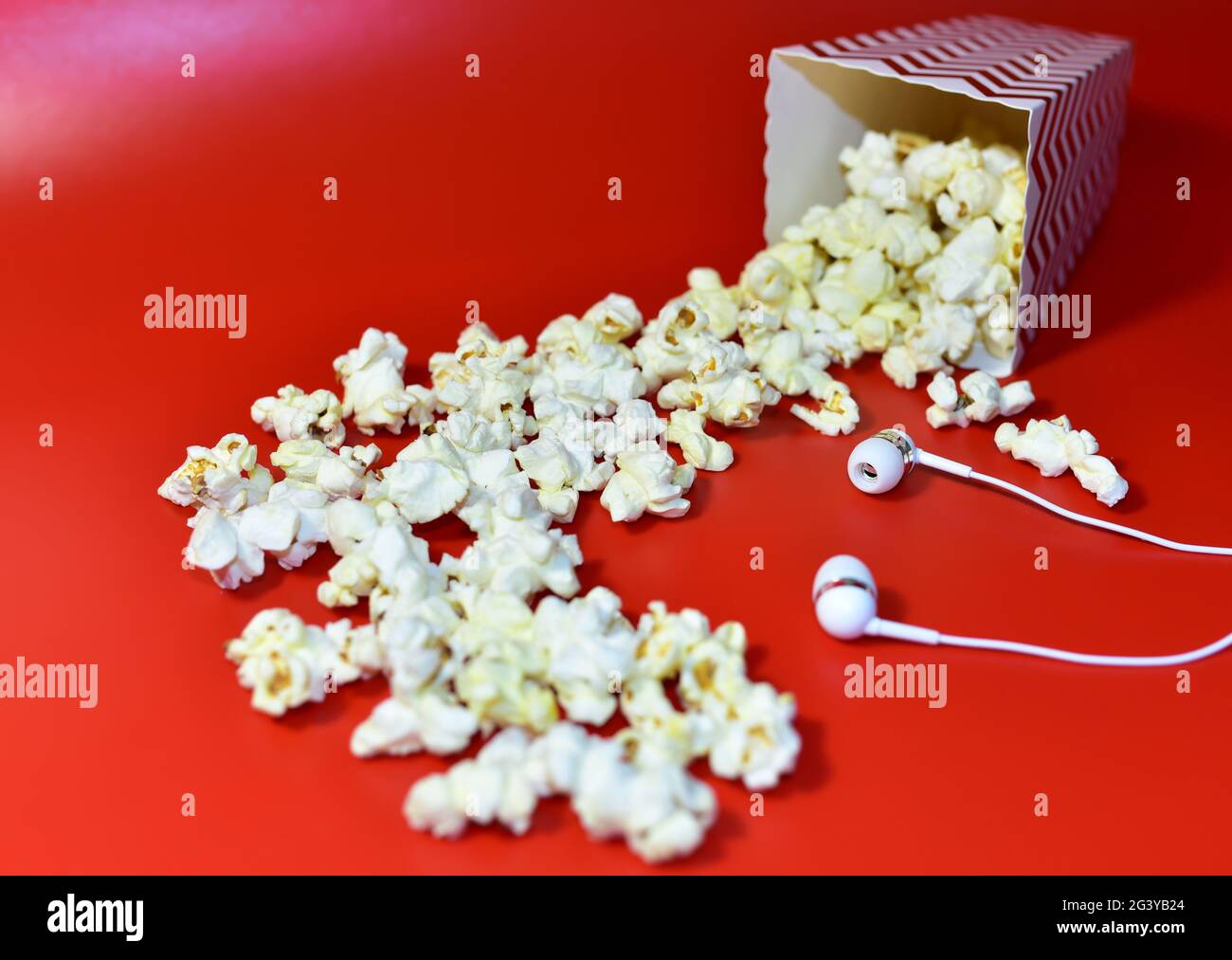 Popcorn in colored cardboard packaging with headphones for listening to ...