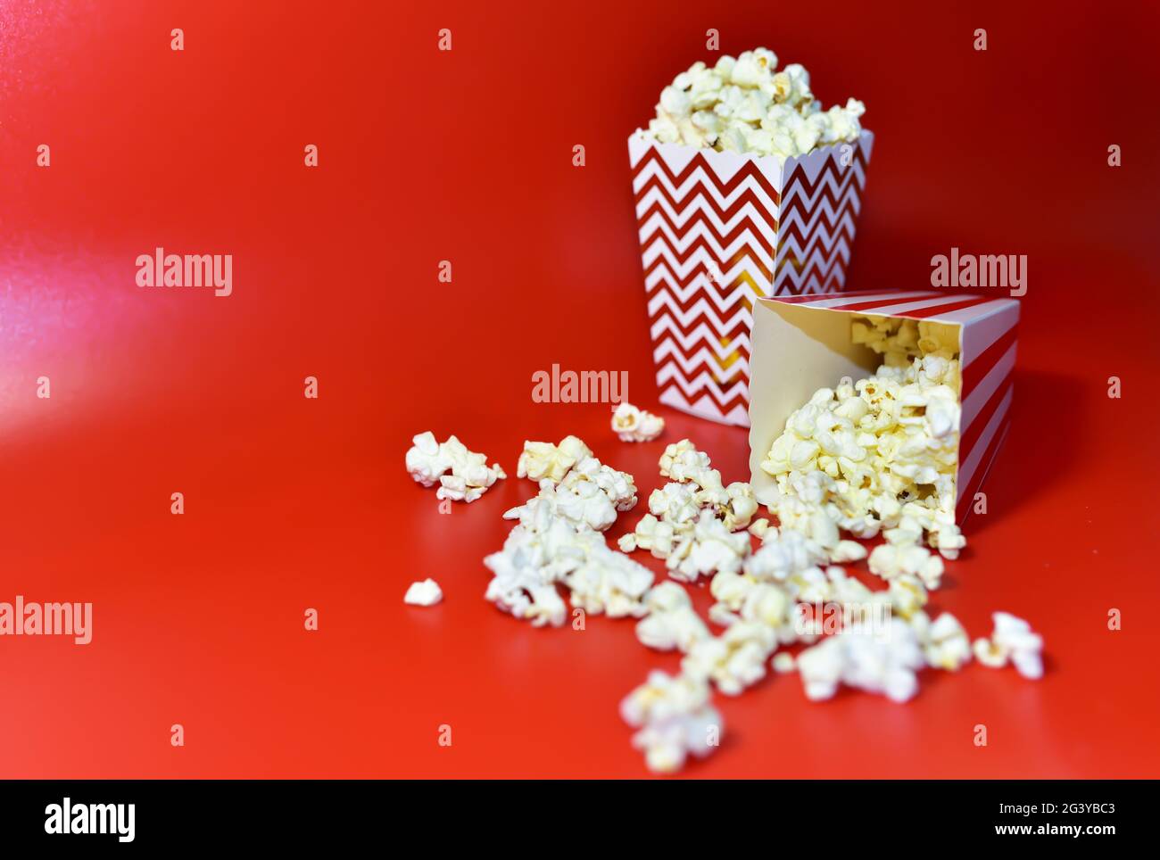 Popcorn in colored cardboard packaging. Heap of salted popcorn in paper ...