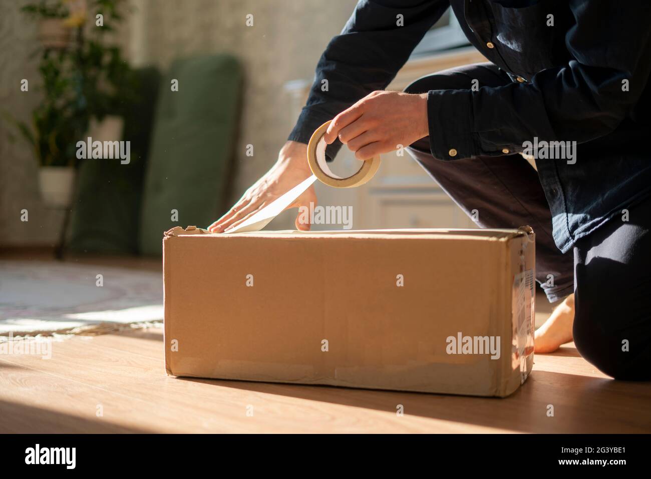 person holding a tape and box to pack the cardboard, send and deliver ...
