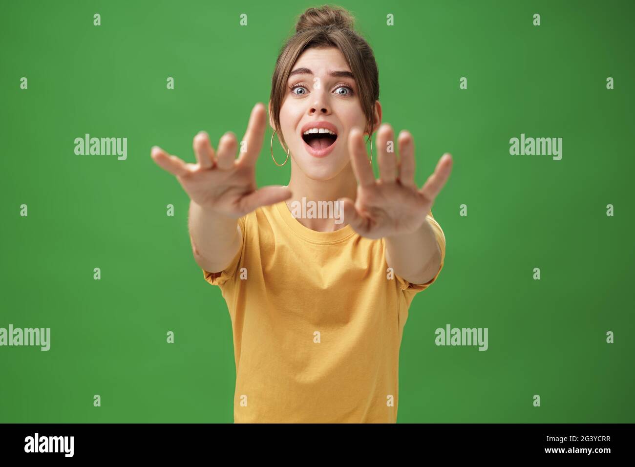 Excited and addicted goog-looking young woman reaching hands forward to ...