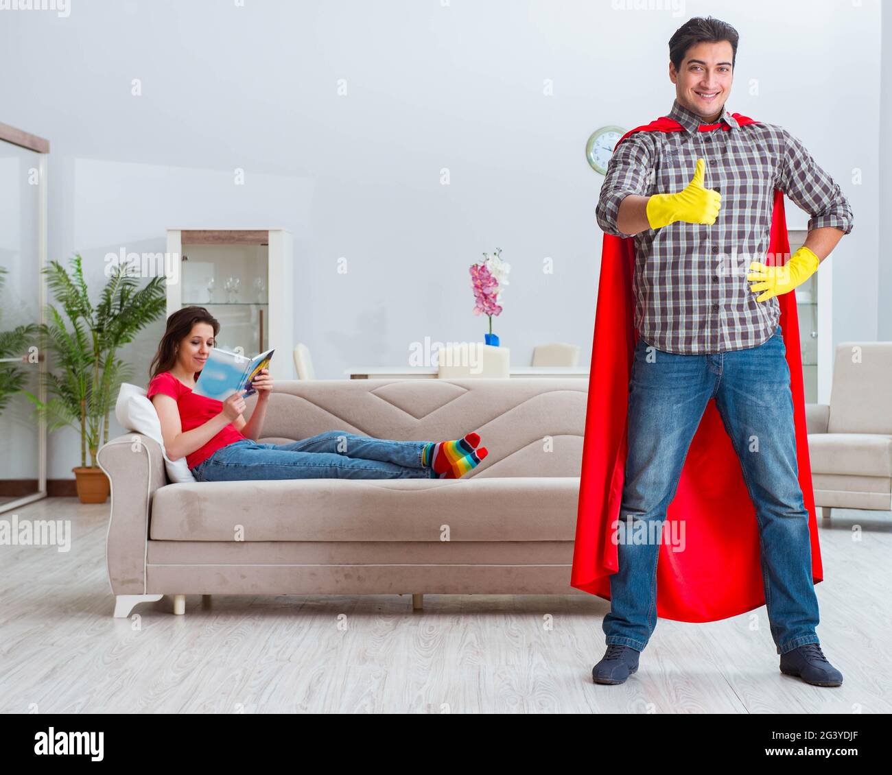 Superhero husband helping his wife at home Stock Photo - Alamy