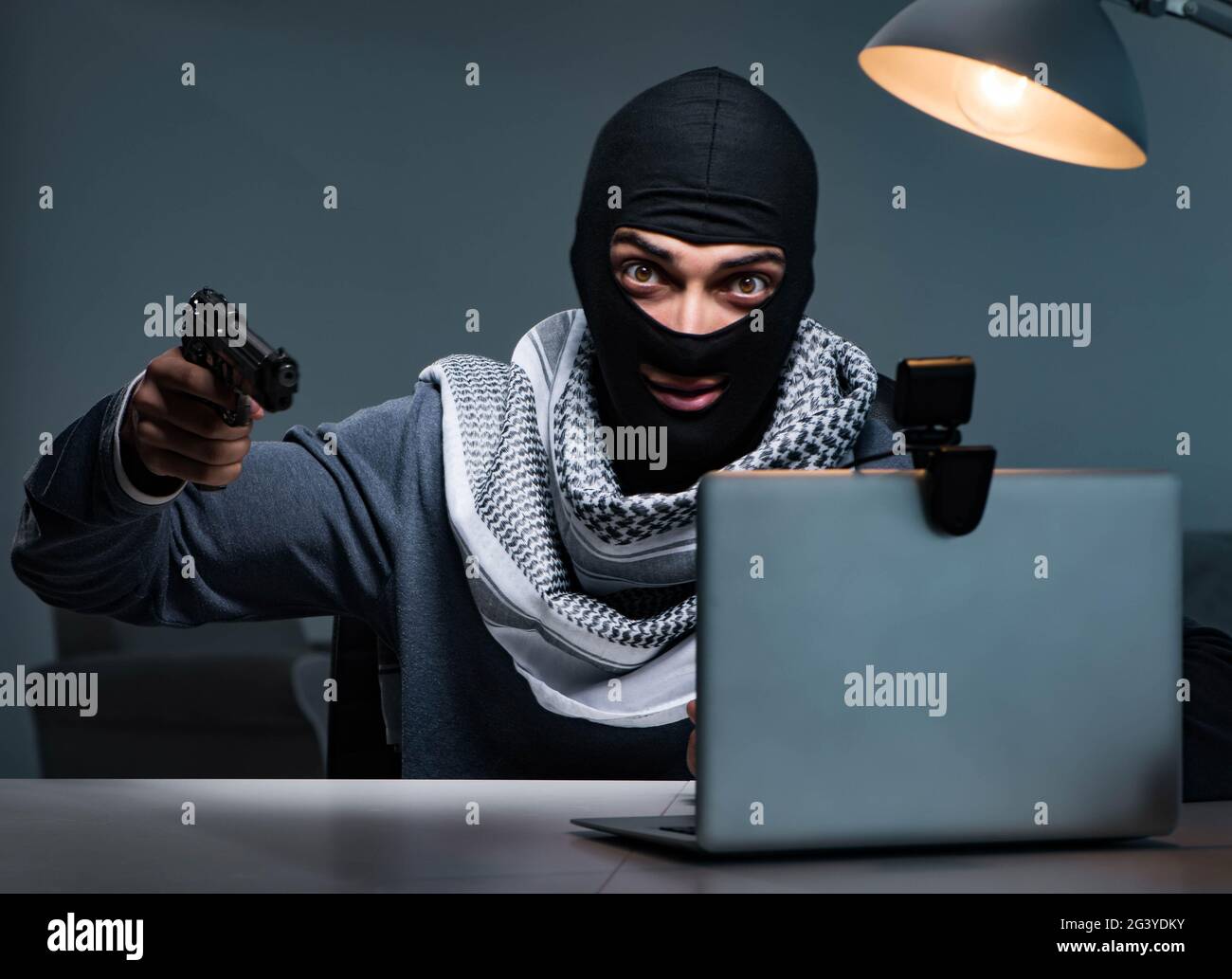 Terrorist burglar with gun working at computer Stock Photo - Alamy