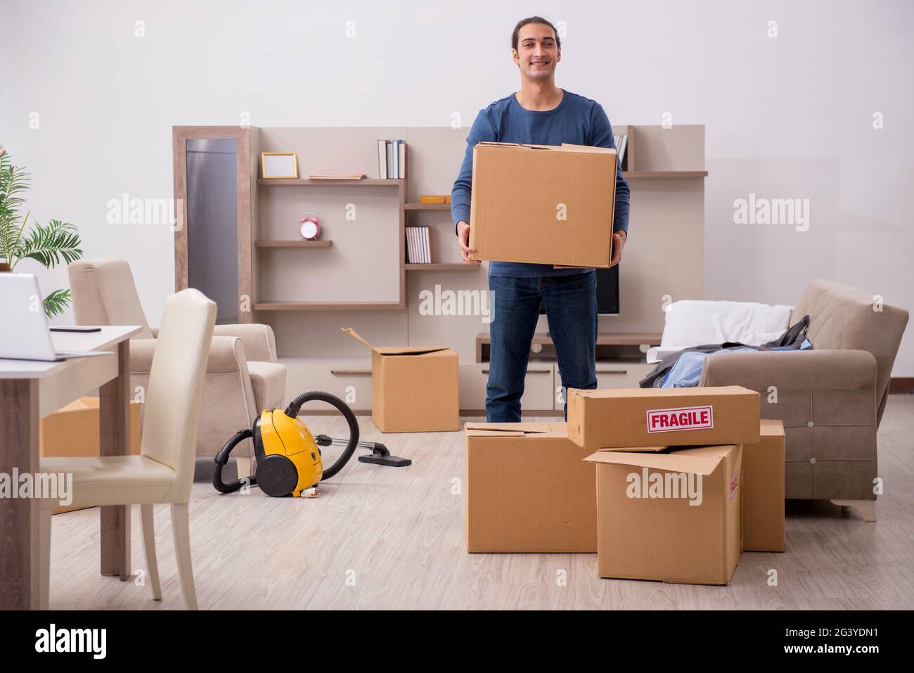 Young man moving to new flat Stock Photo - Alamy