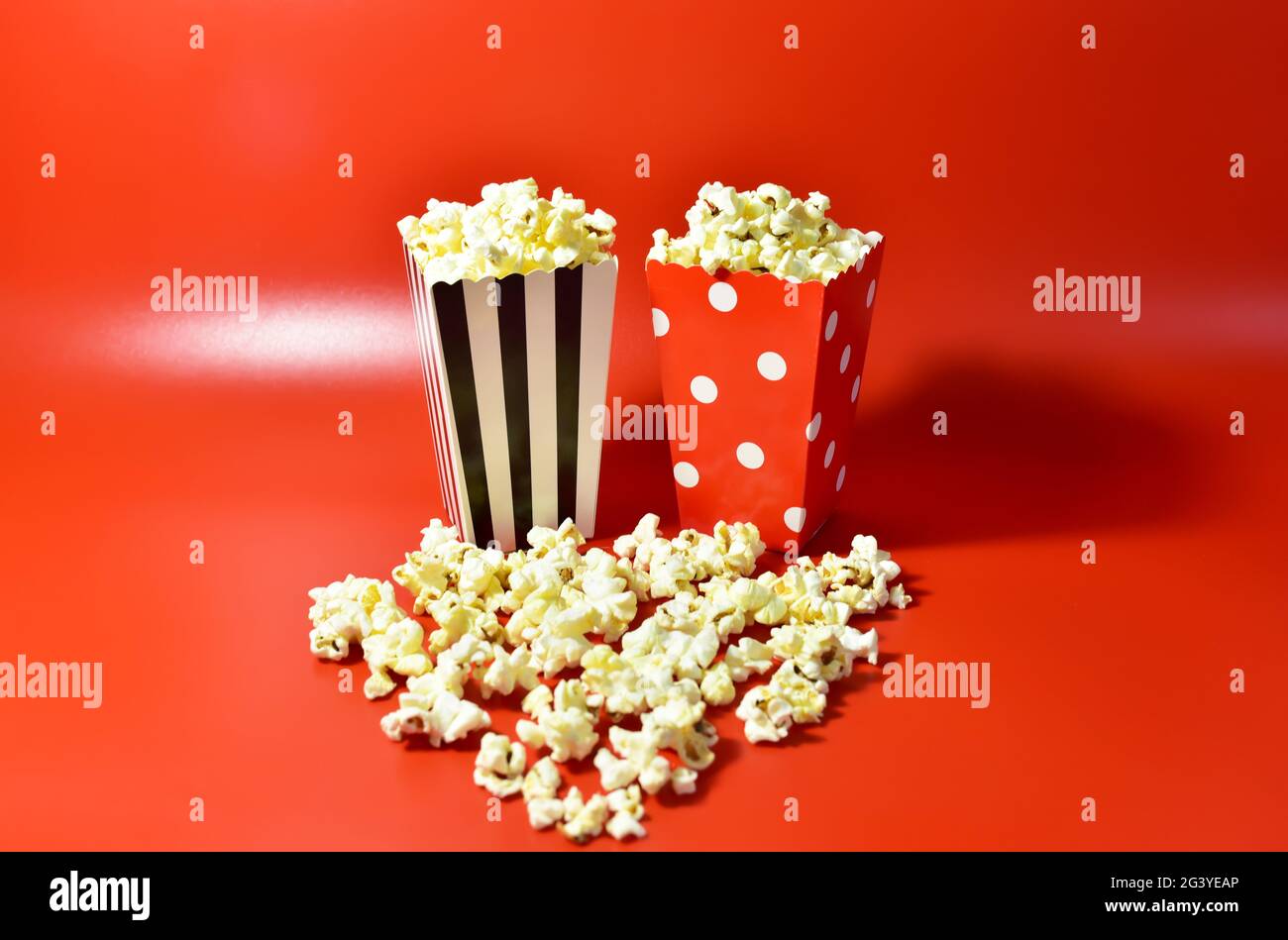 Popcorn in colored cardboard packaging. Heap of salted popcorn in paper ...