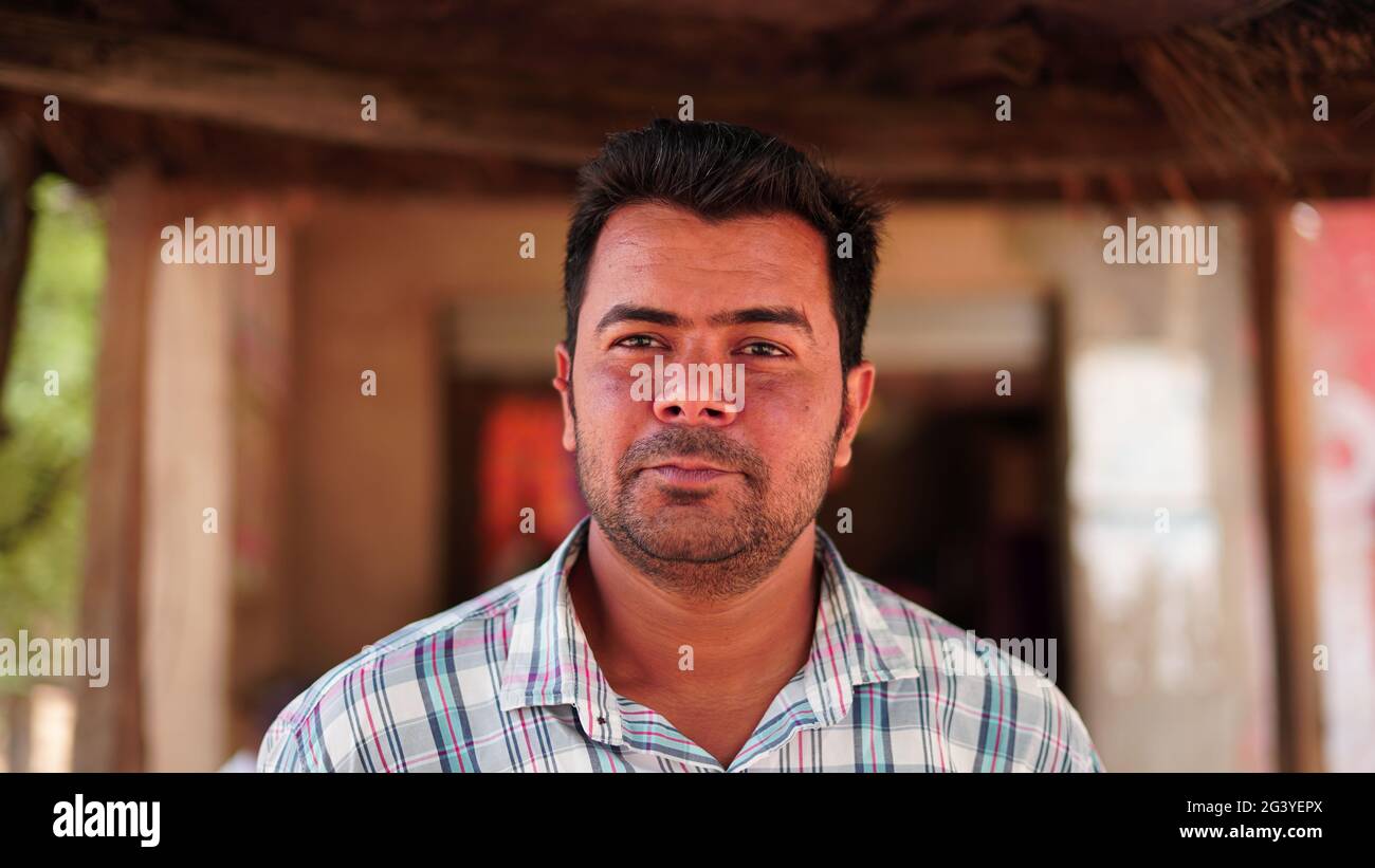 Young handsome Asian man wearing check shirt over blur background ...