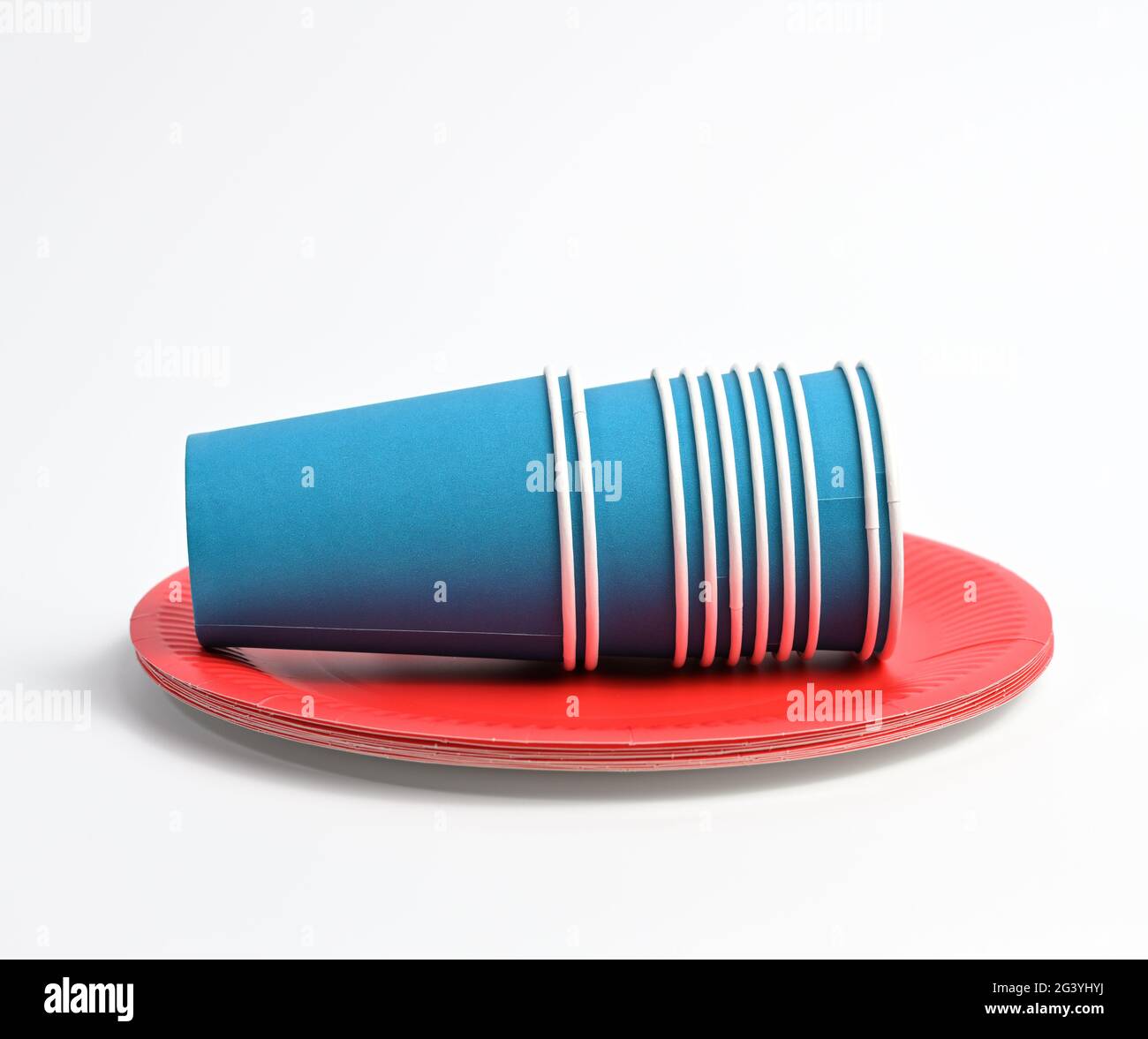 Stack of blue paper cups and red round plates on a white background ...