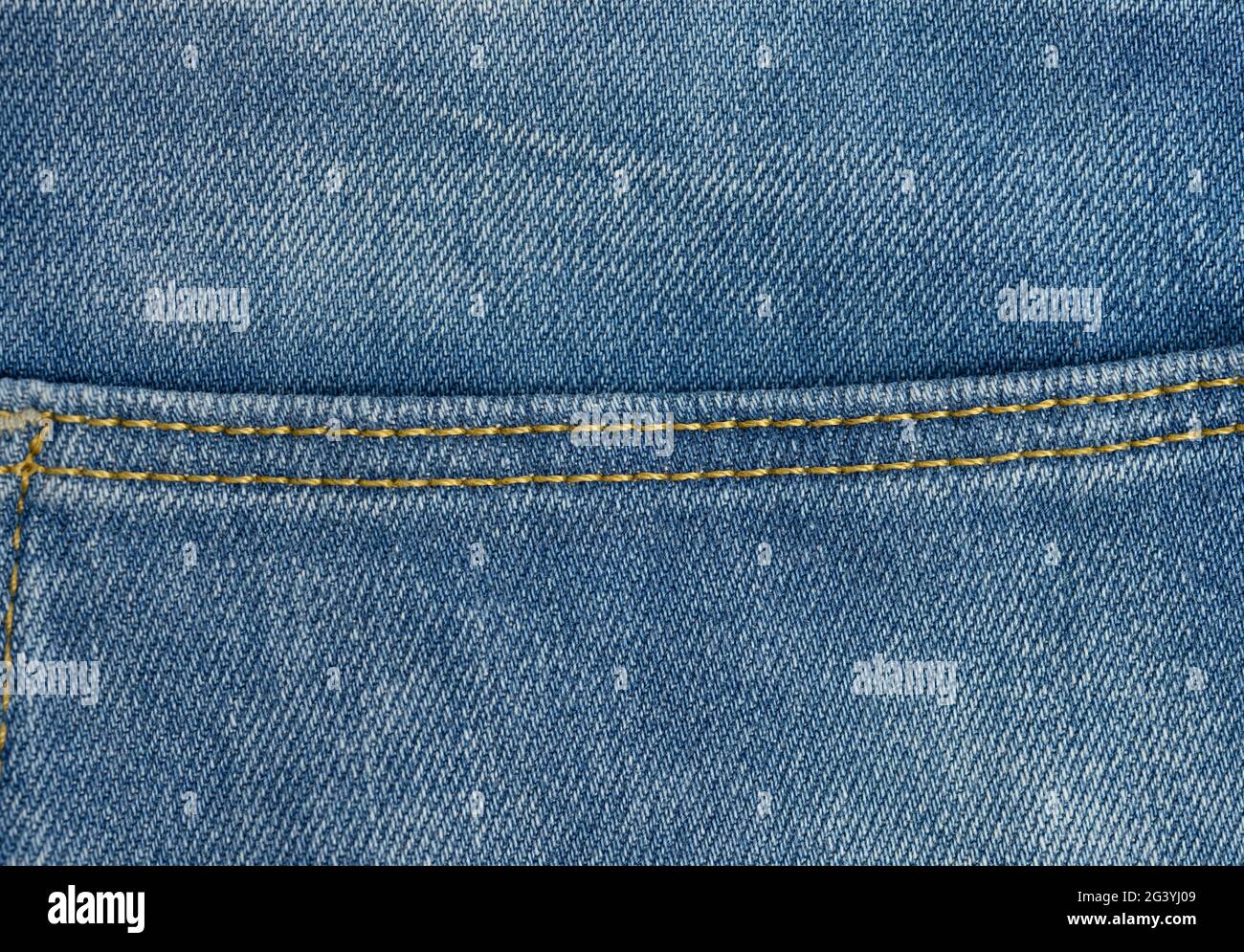 Sewing line from brown threads on blue jeans Stock Photo - Alamy