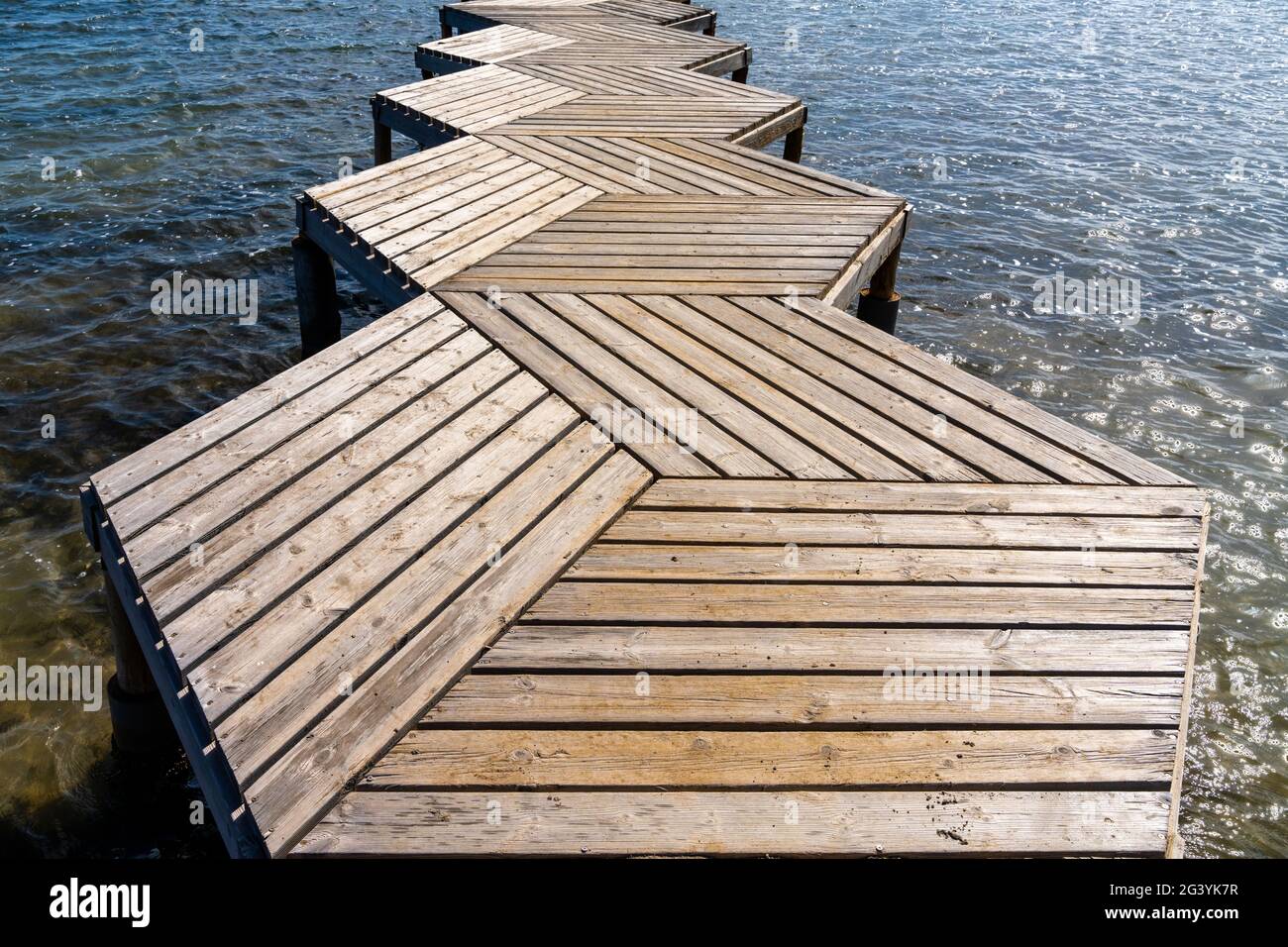 A close up low angle abstract view of a wooden boardwalk and pier ...