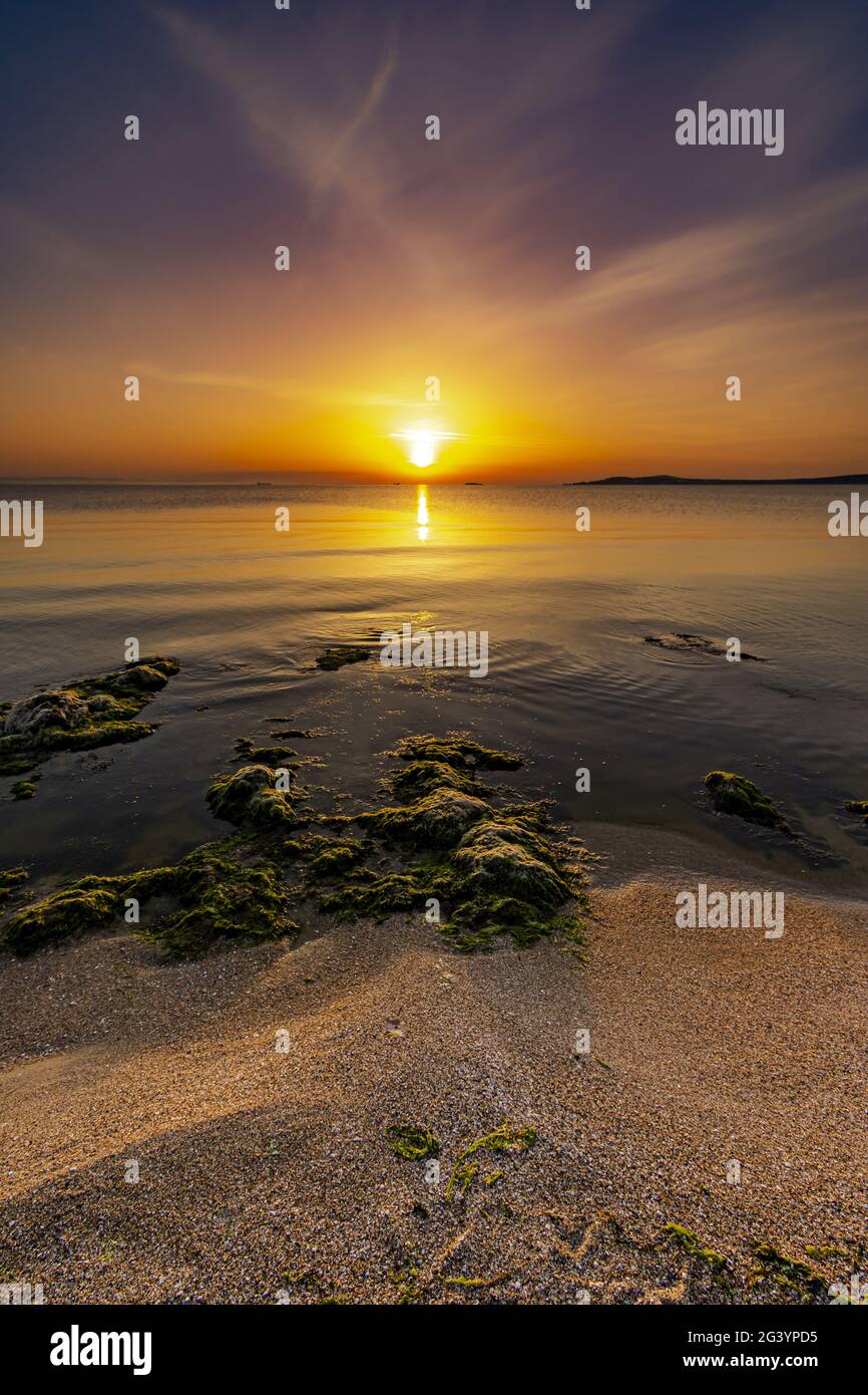 Beautiful sunset reflected on the water Stock Photo - Alamy