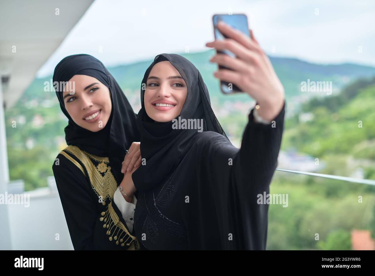 Portrait of young muslim women taking selfie on the balcony Stock Photo ...