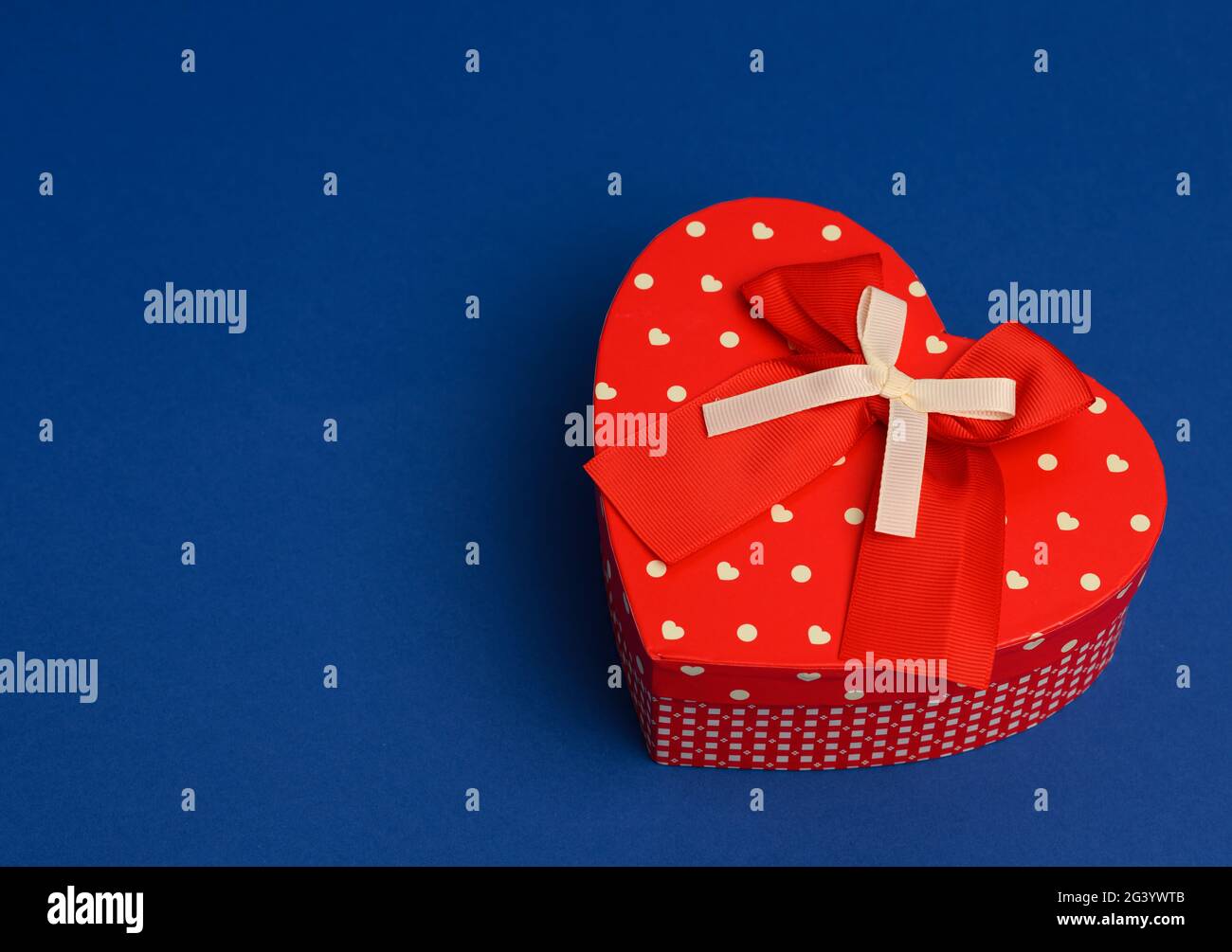 Red heart shaped gift box on blue background Stock Photo - Alamy