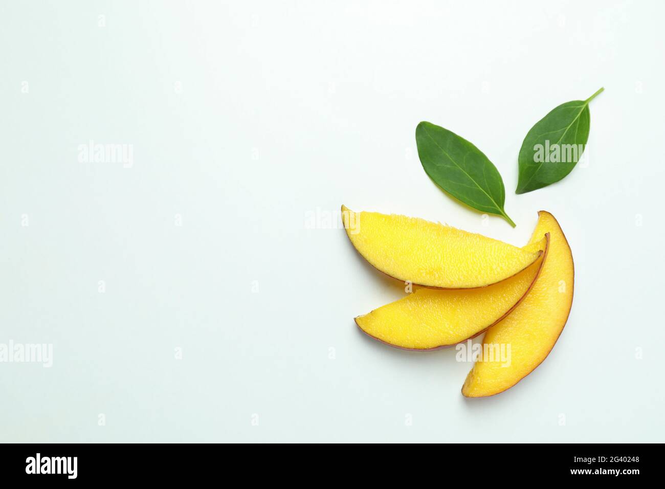 Ripe mango fruit slices on white background Stock Photo - Alamy