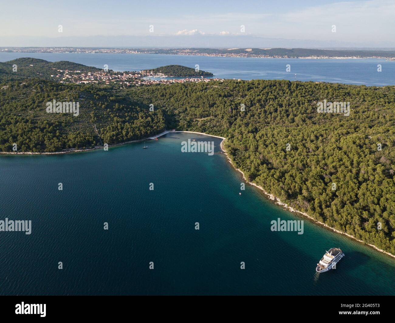 Aerial view of cruise ship at anchor in pristine bay, near Kukljica ...